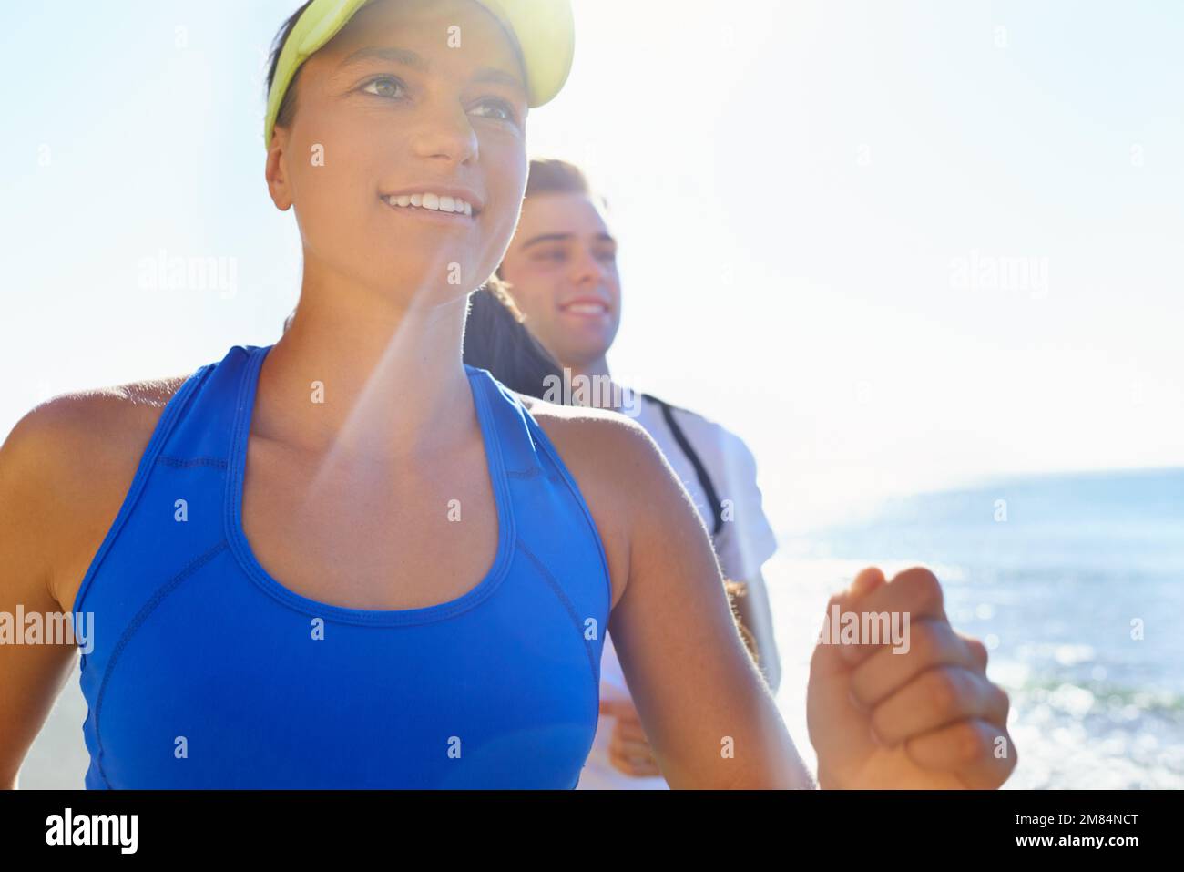 Running with a loved one. A young couple running together at the coast ...