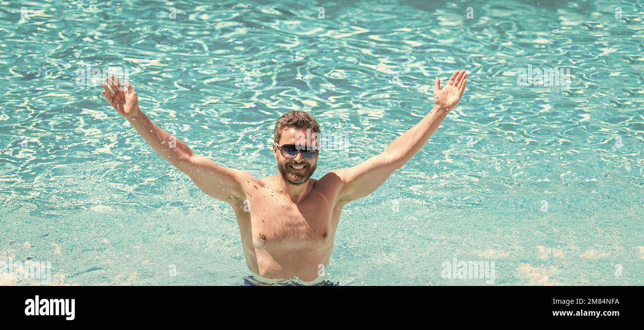 happy handsome guy in sunglasses swimming in pool on summer, pool party ...