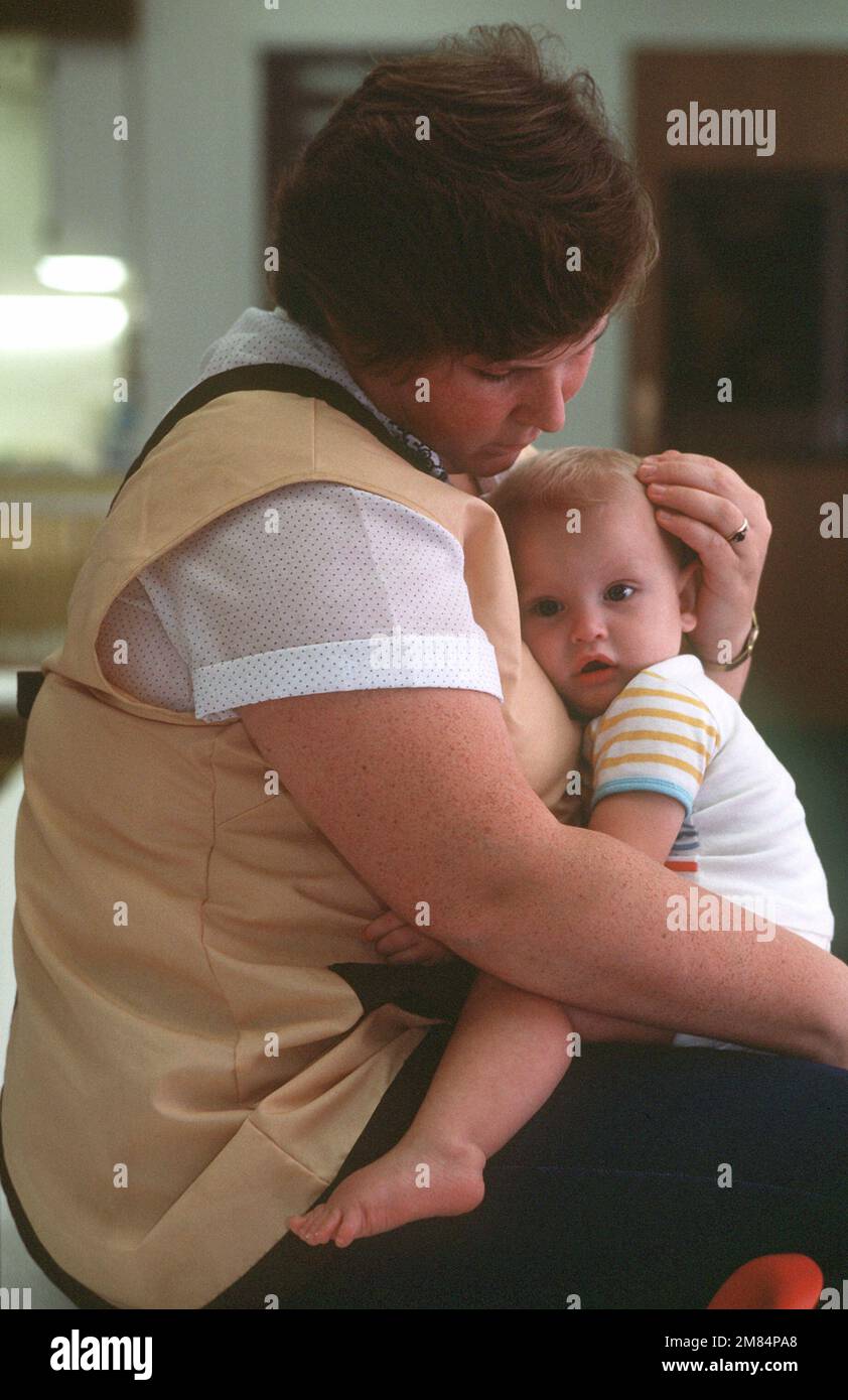 A worker comforts a child at a recently opened day care center. The new ...
