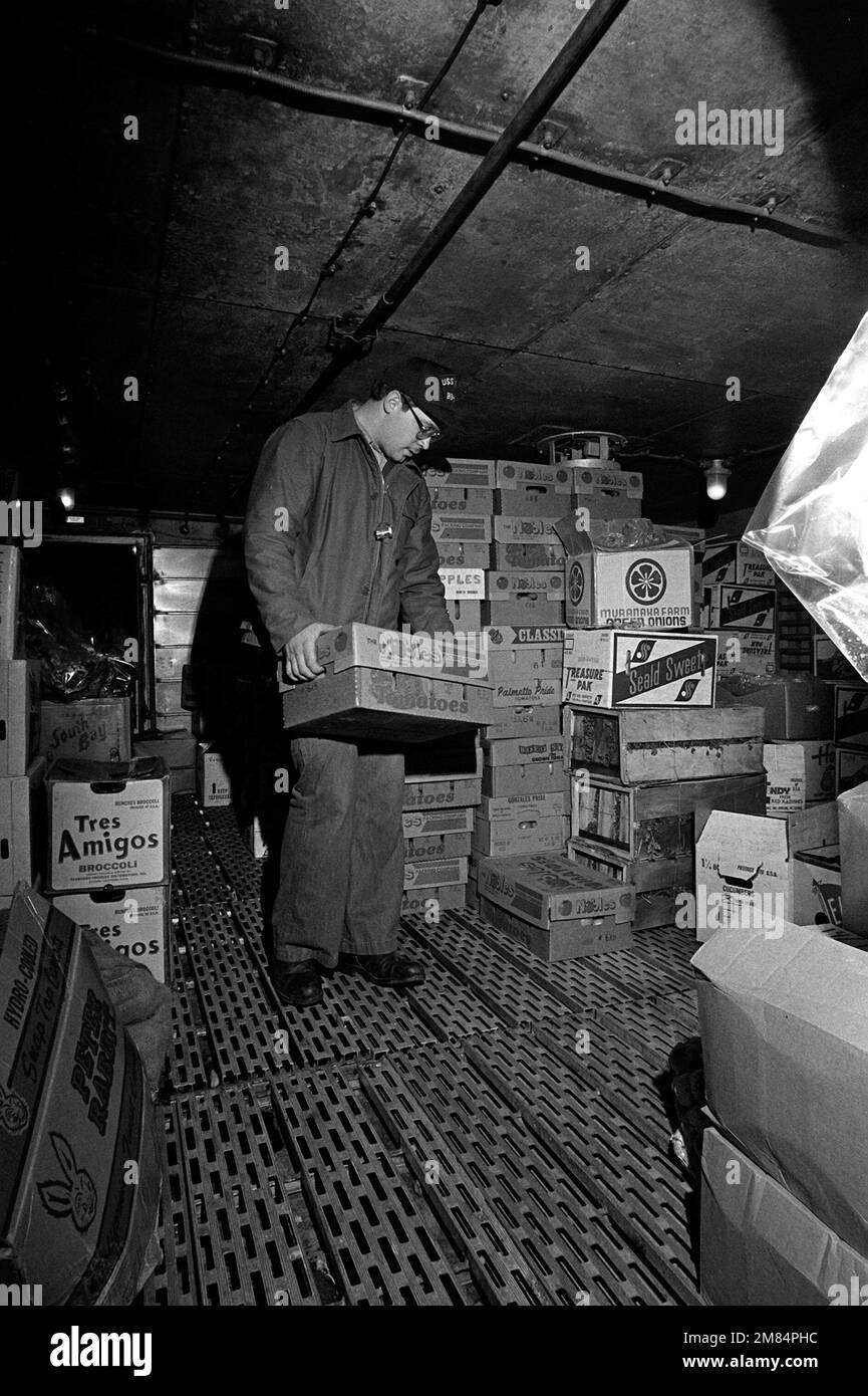 A food service attendant moves supplies to the mess preparation area ...