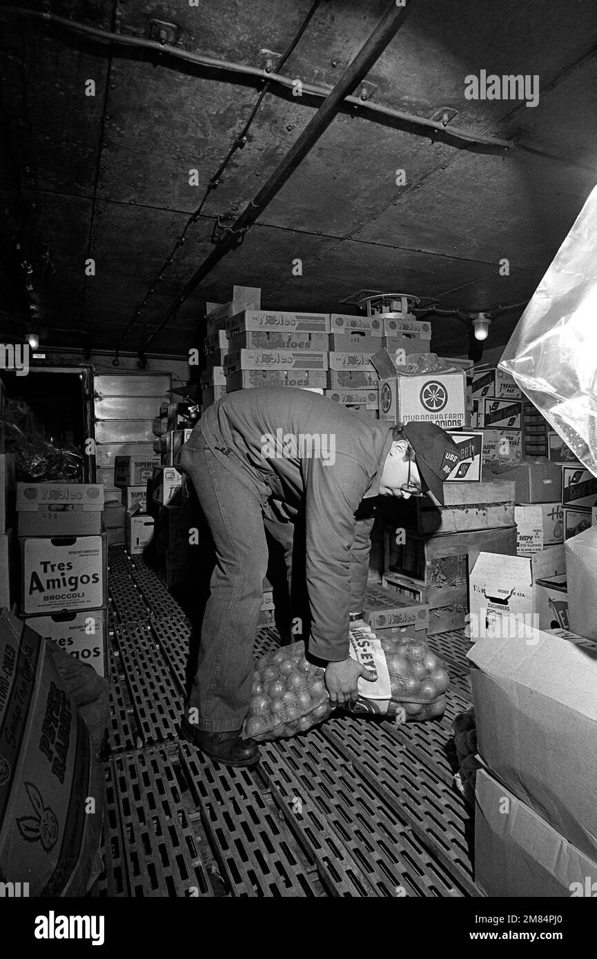 A food service attendant moves supplies to the mess preparation area ...