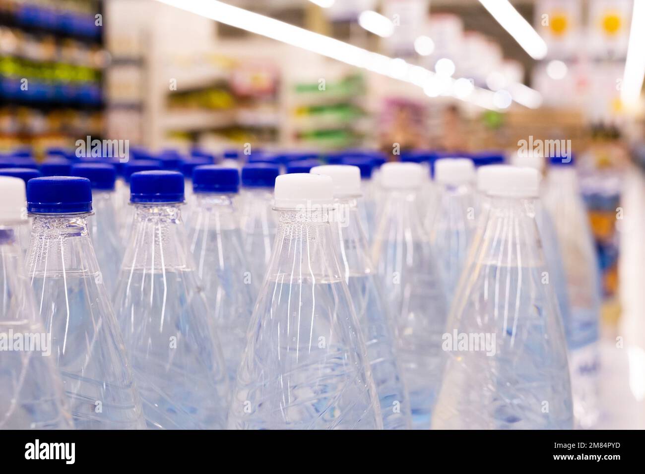 water bottles with blue caps in supermarket Stock Photo - Alamy