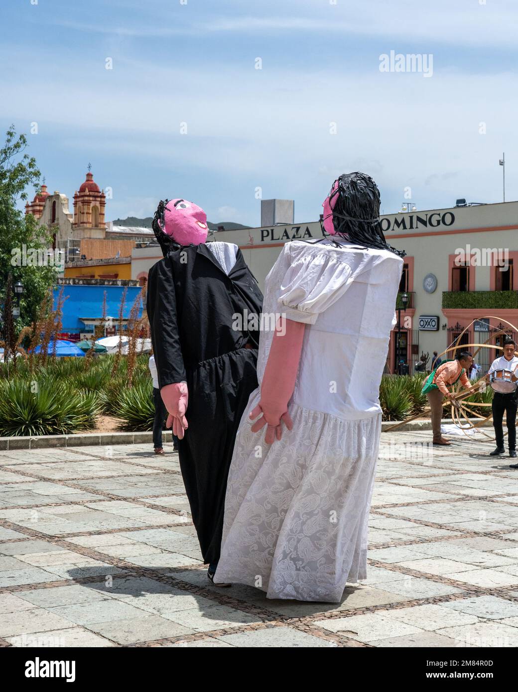 Giant bride and groom puppets dance before a wedding celebration at the ...