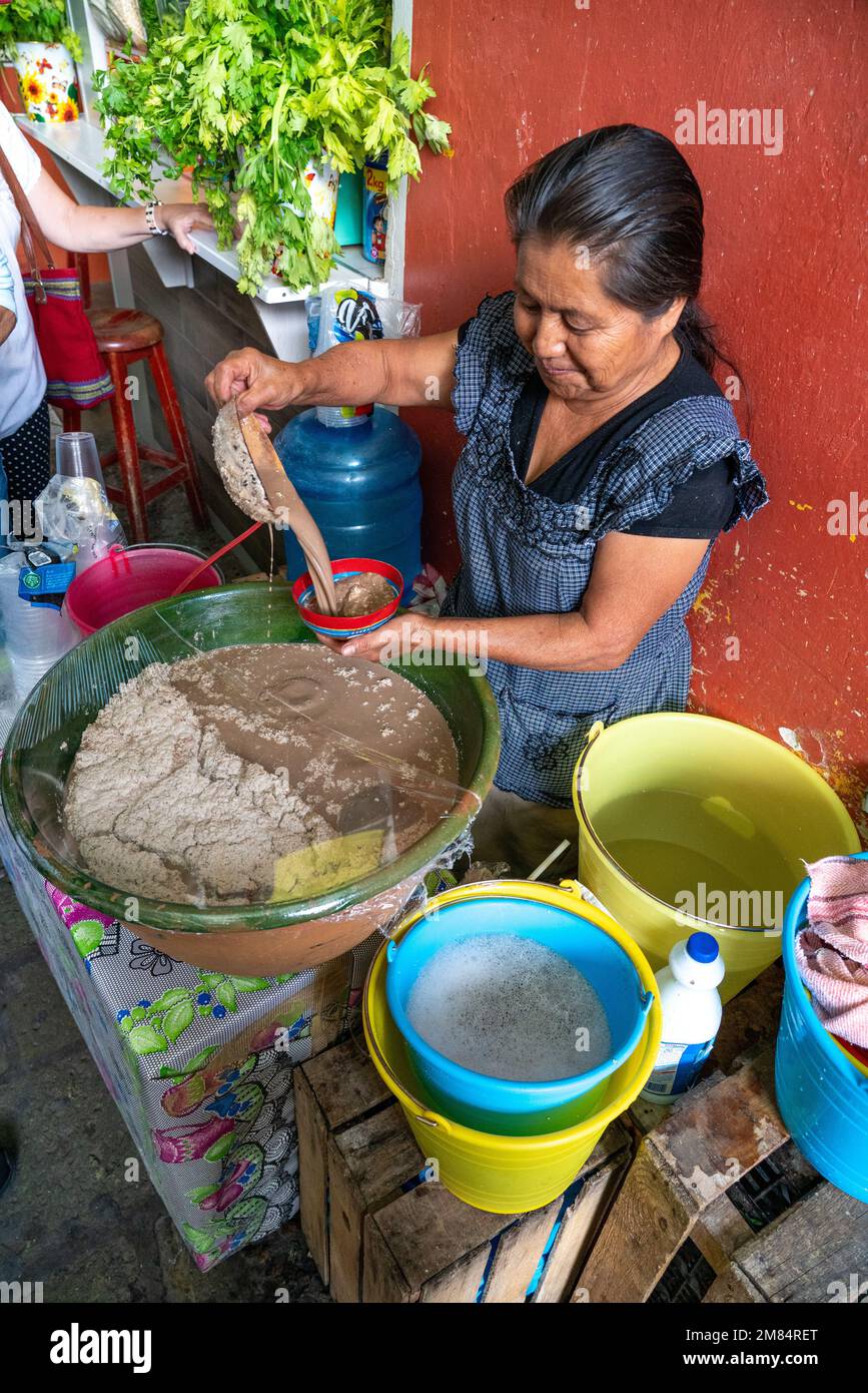 An indigenous woman pours a maize drink called tejate in the Benito ...