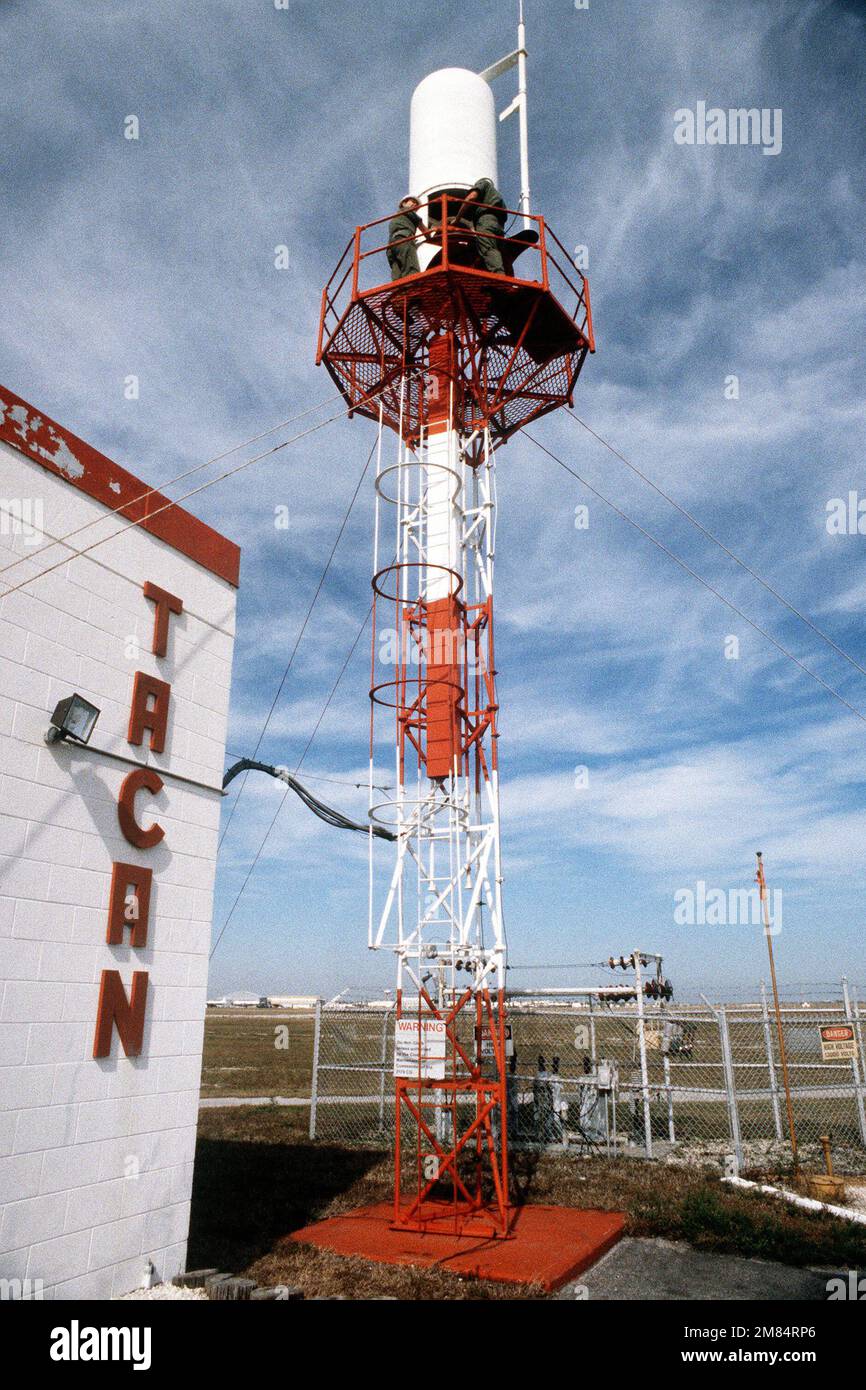 Workers check the antenna in a radome on top of a 2179th Information ...