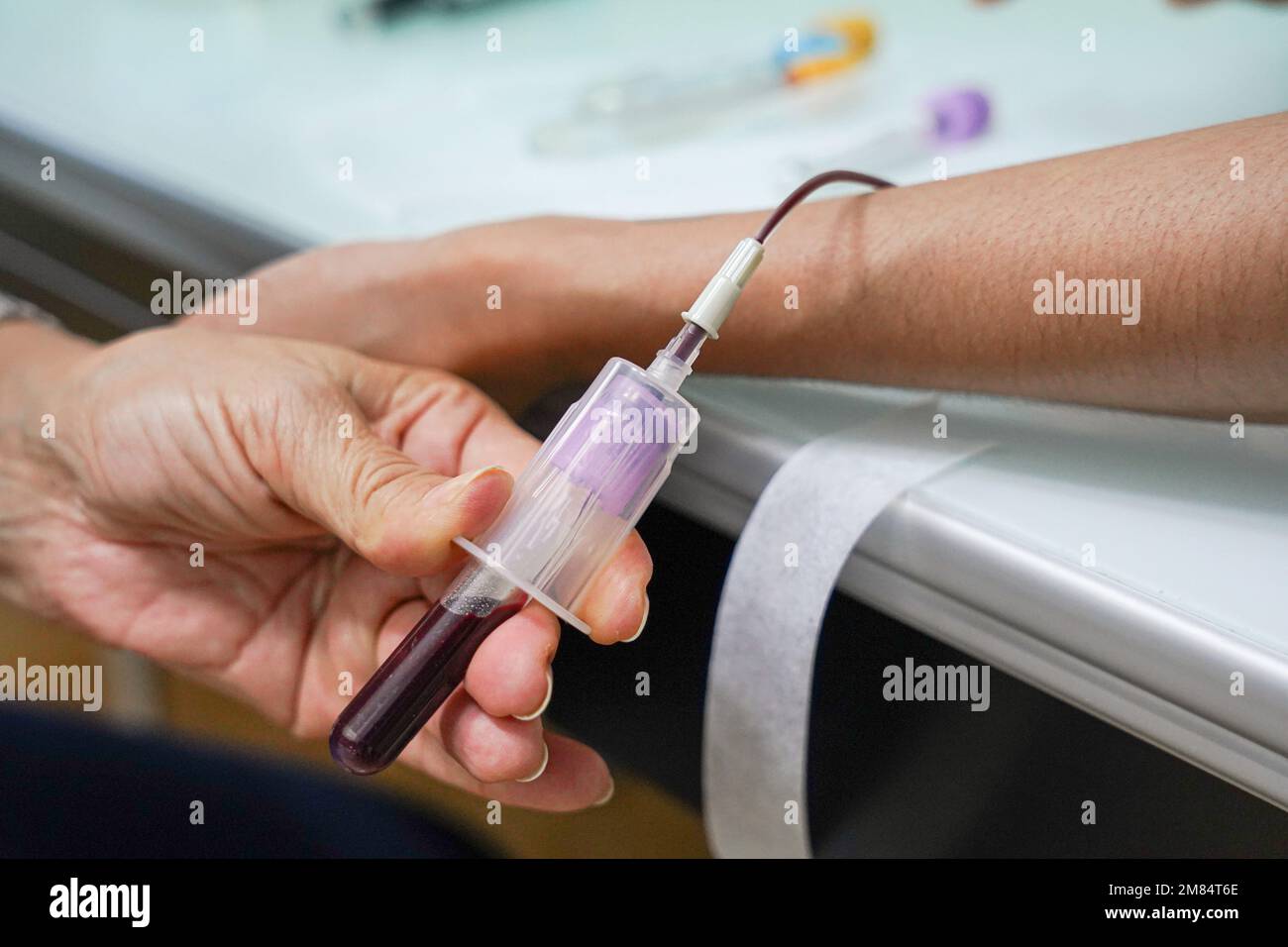 unrecognizable nurse drawing blood from a patient at home. Blood ...