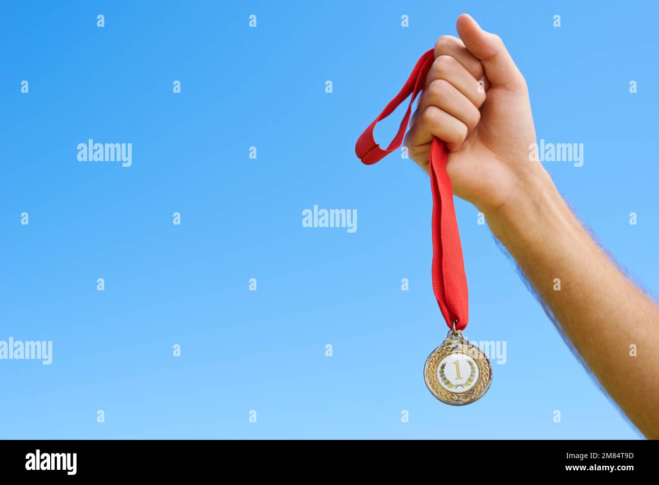 Holding up the gold medal. a person holding a gold medal Stock Photo ...