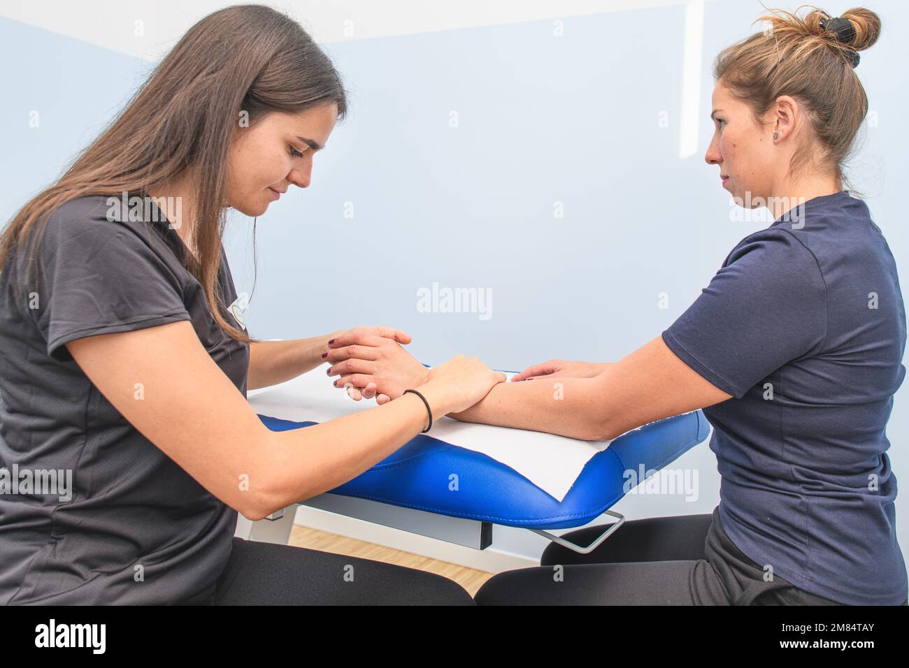 A Physical Therapist Performs Wrist Mobilization To A Patient Stock ...