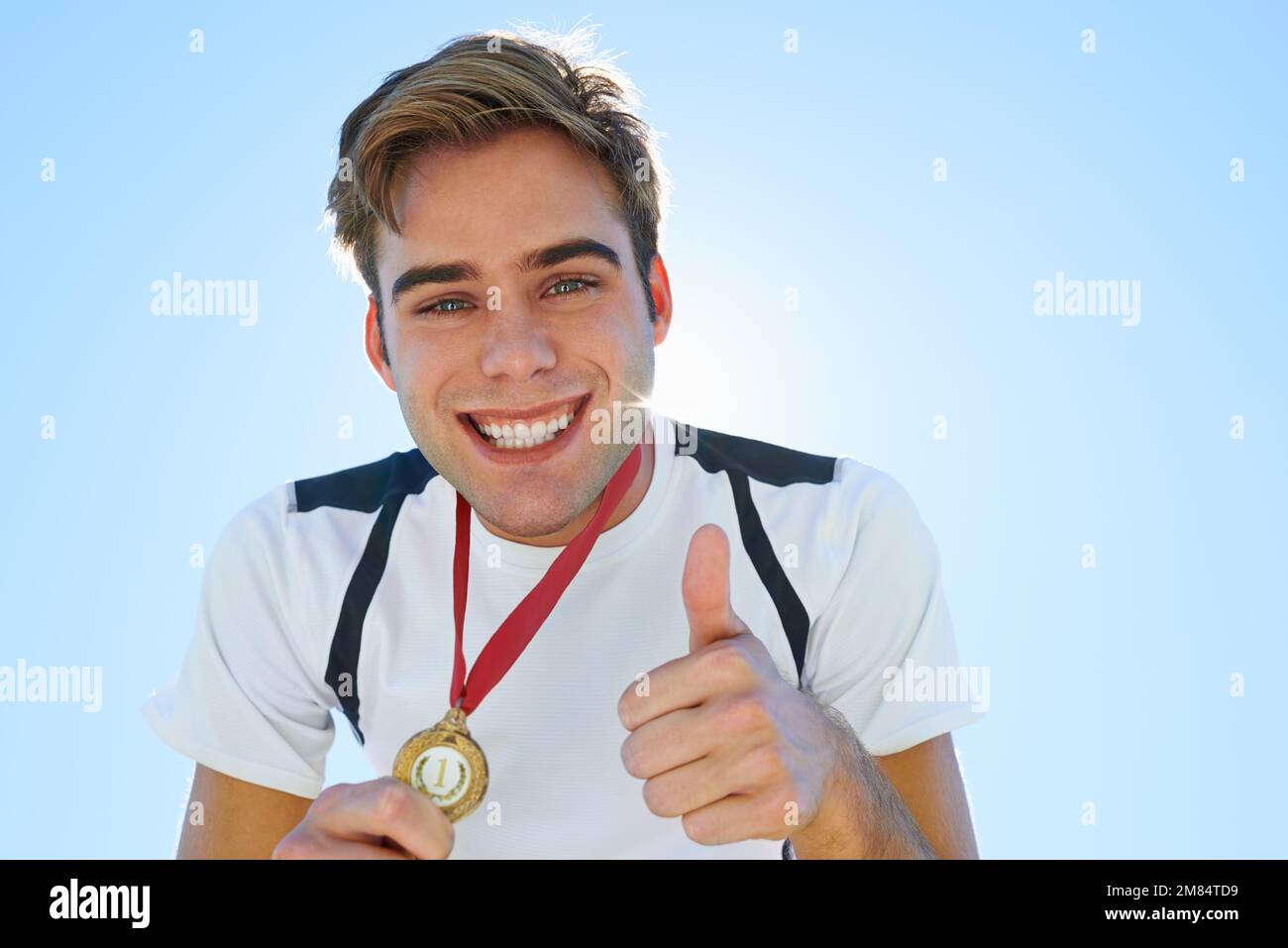 And the gold goes to...me. Smiling medal winner gesturing thumbs up ...