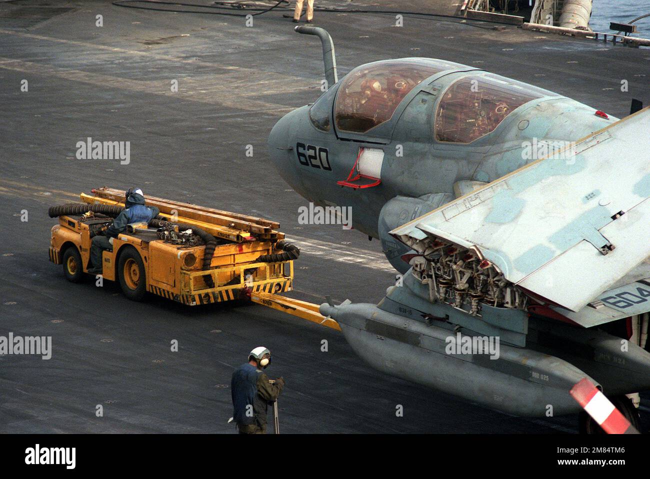 An MD-3A tow tractor tows an EA-6B Prowler aircraft across the flight ...