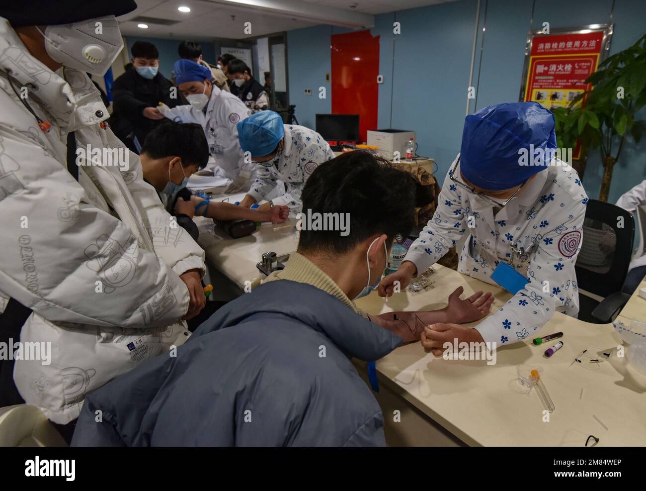 Fuyang, China. 12th Jan, 2023. A nurse draws blood from a young man for ...