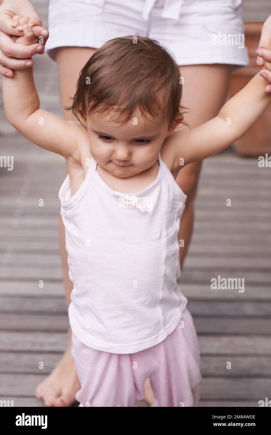 Learning to balance...a mother helping her baby daughter learn how to ...