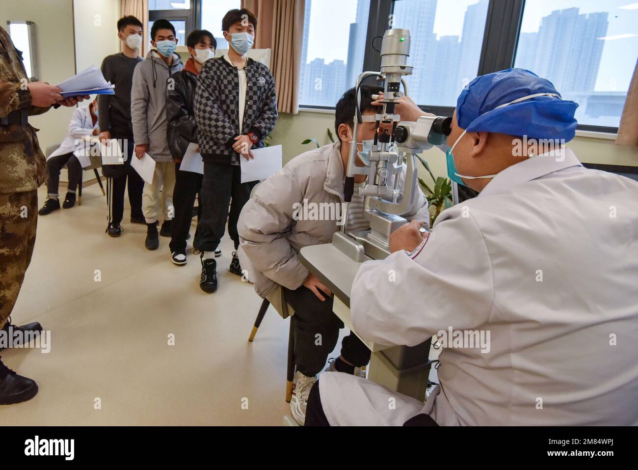 Fuyang, China. 12th Jan, 2023. A doctor examines the eyes of a young ...