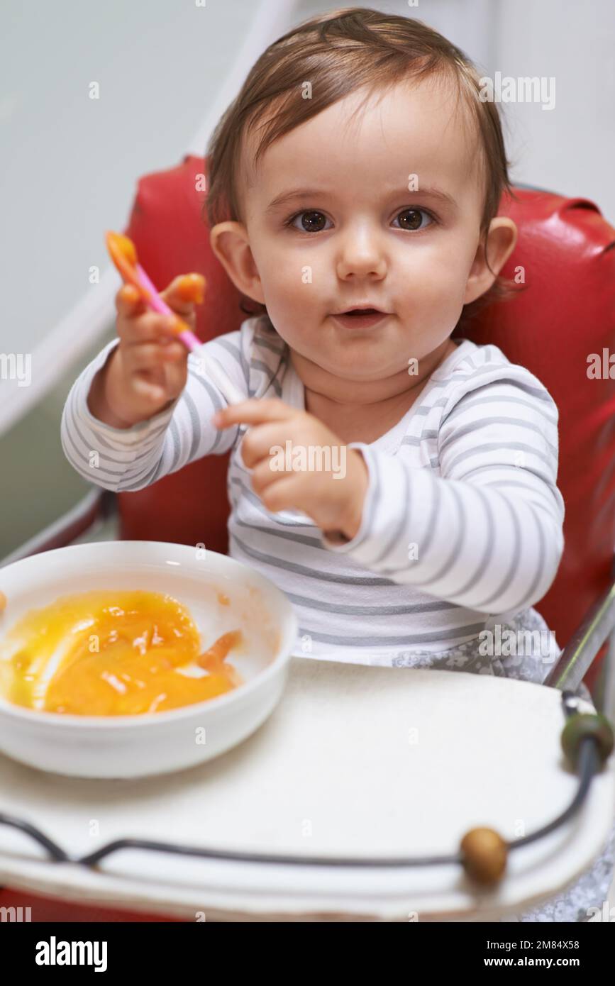 Hand...spoon...who cares. Portrait of a cute little baby sitting in a ...