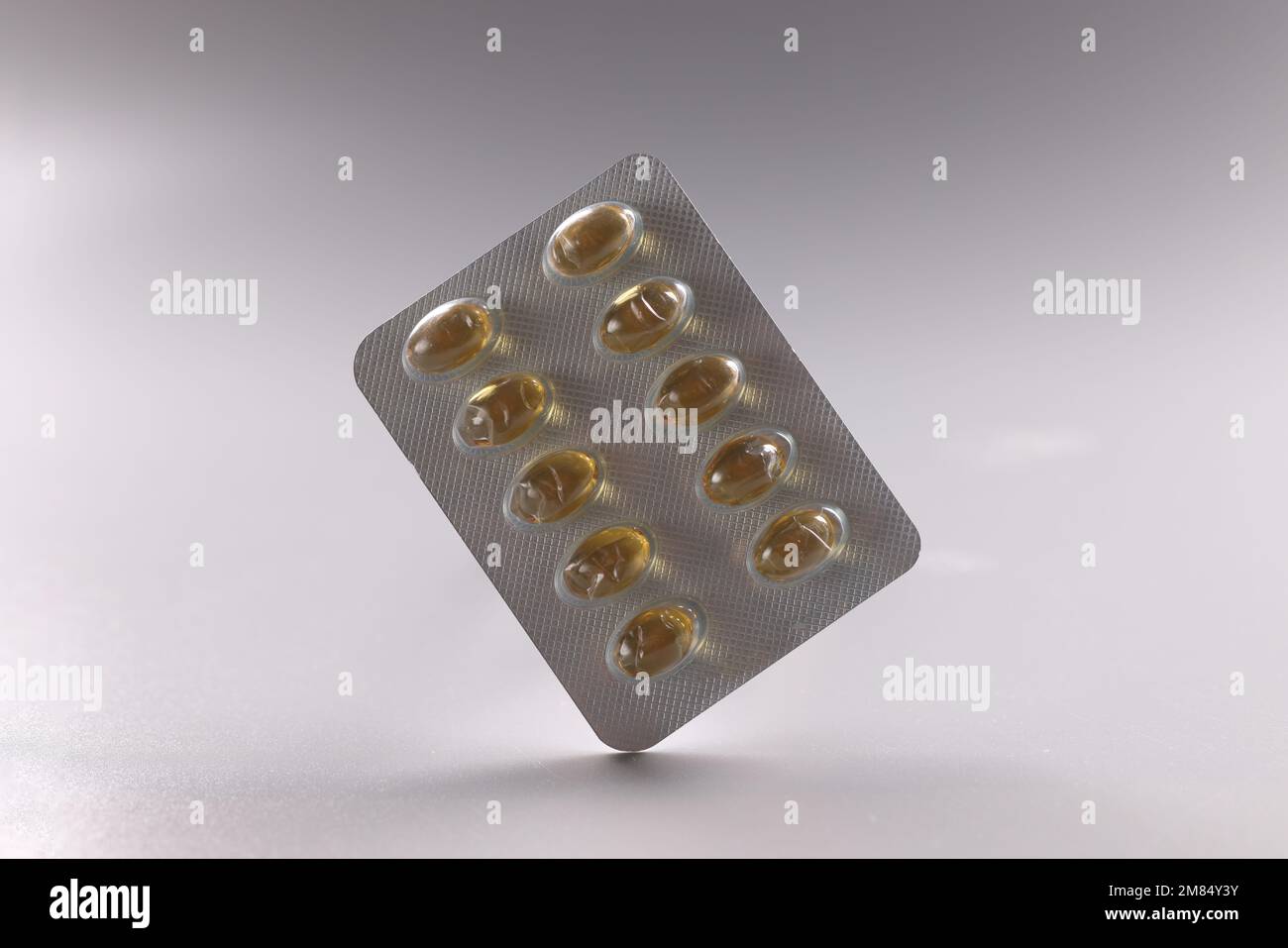 Fish oil Omega 3 tablets in blister pack with capsules on gray ...