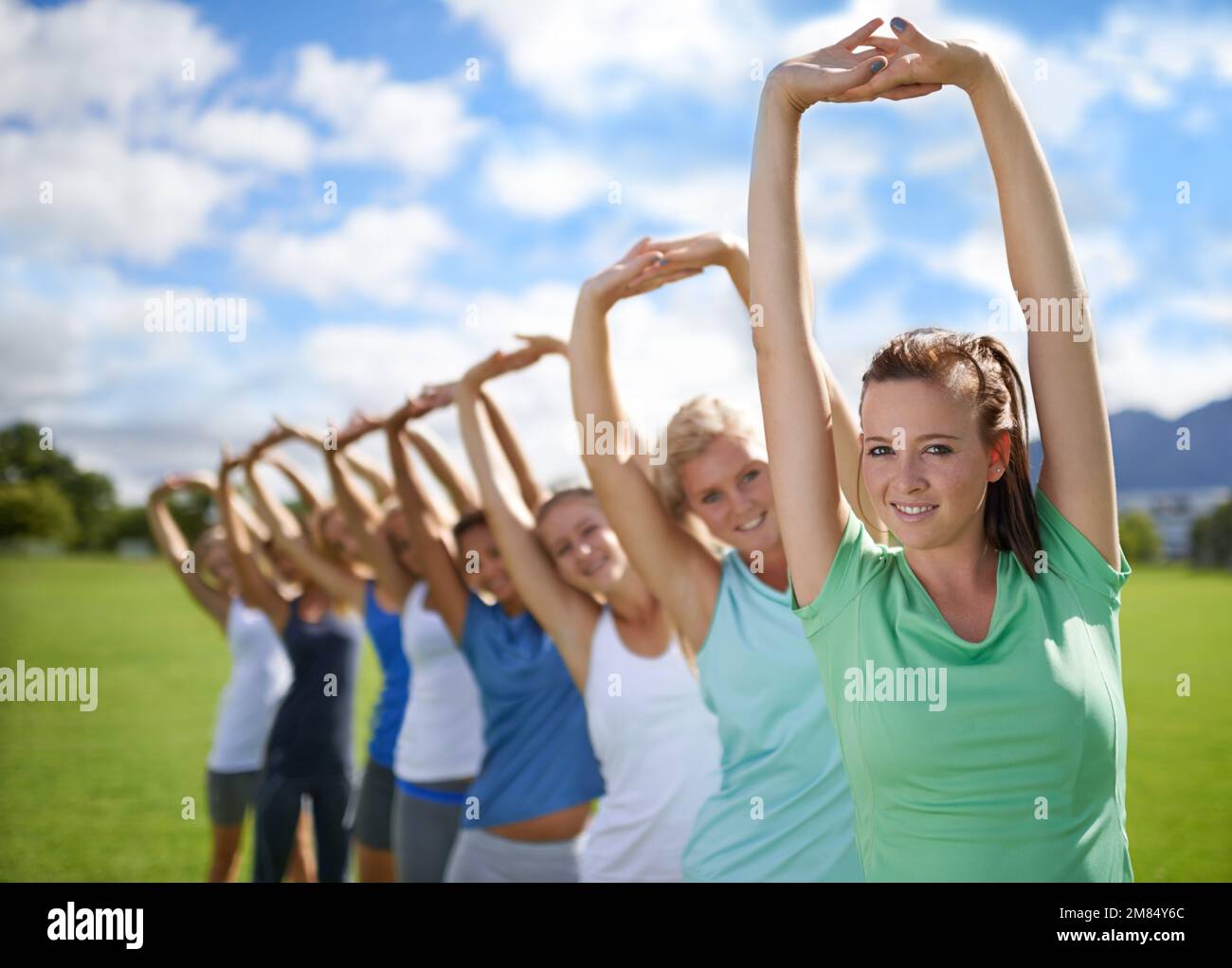 A group of teenage girls stretching. a group of young women exercising ...