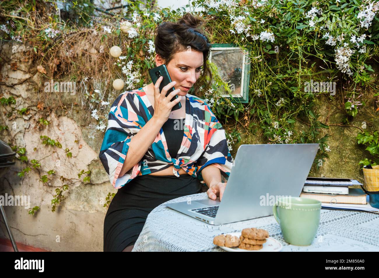 Caucasian adult woman of French ethnicity, working on the terrace with ...