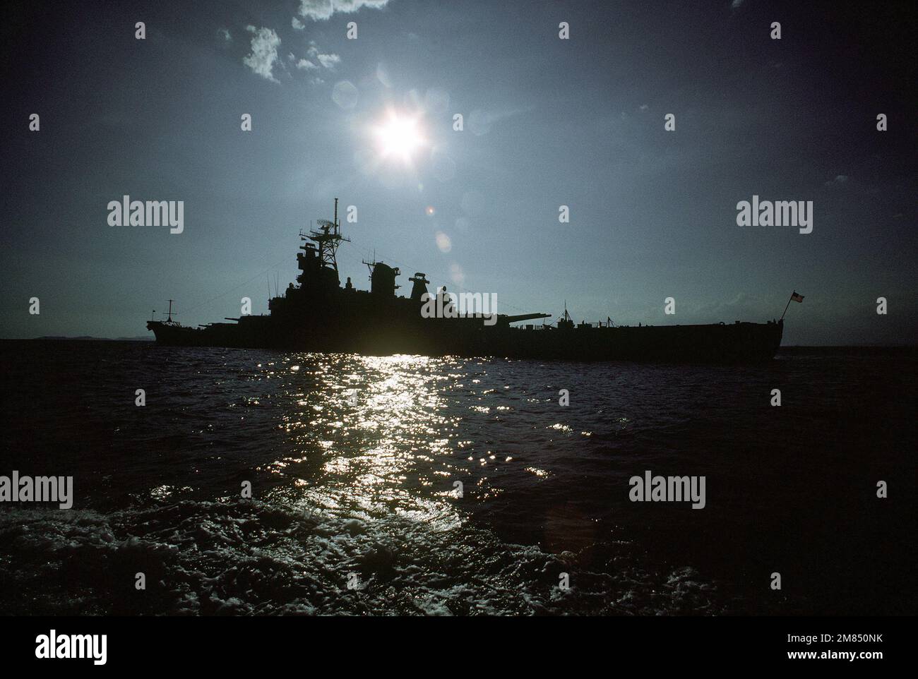 A silhouetted port side view of the battleship USS IOWA (BB-61) at ...