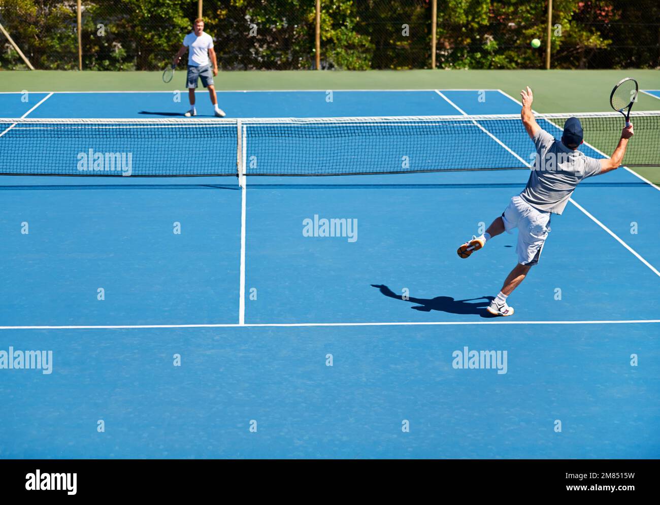 Showing up to every tennis practice. two people playing tennis outside ...