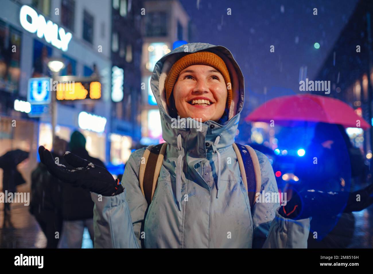 snowfall woman in a blue jacket and yellow hat christmas outside, city ...