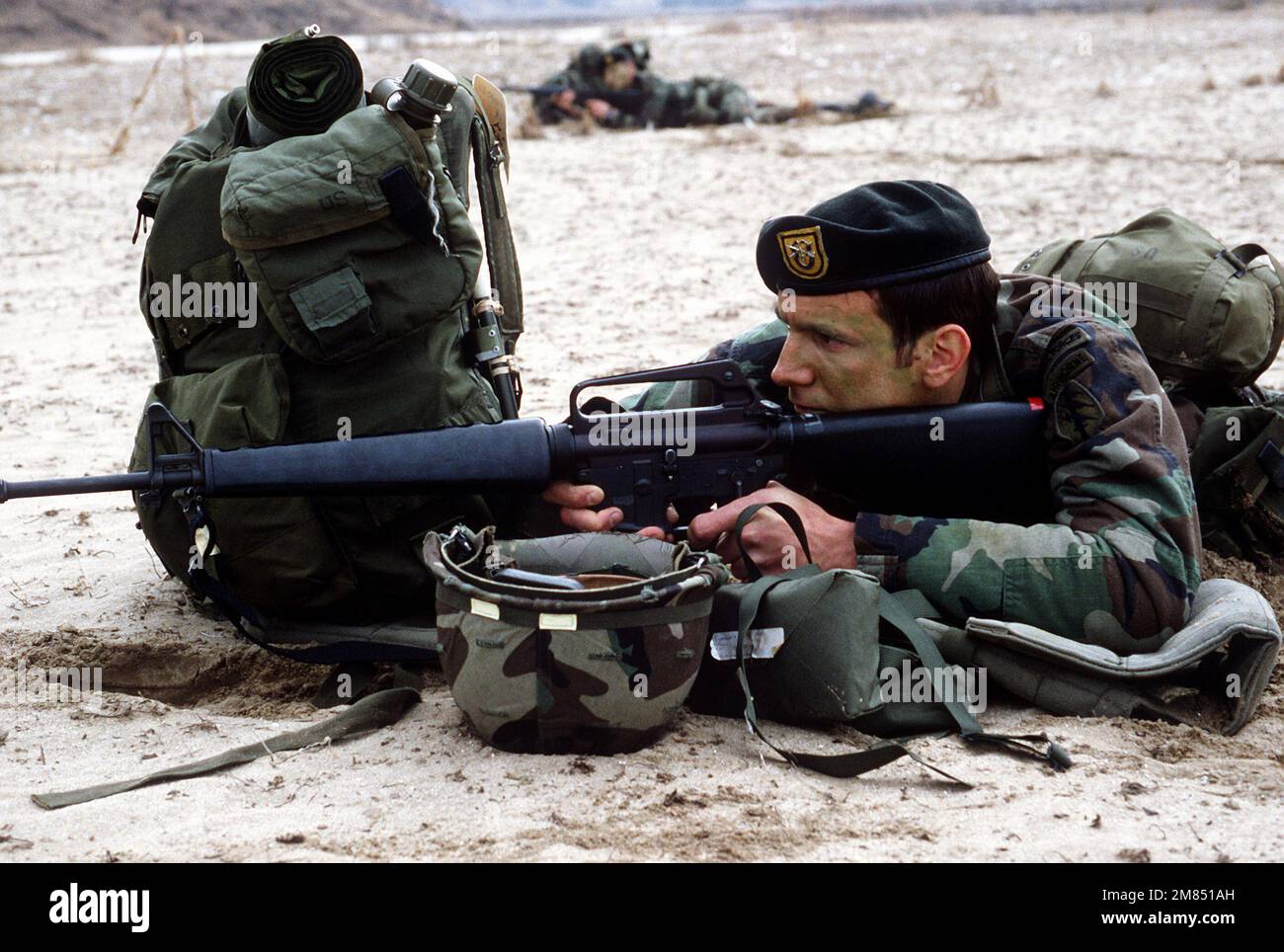 A member of the 12th Special Forces aims his M-16 rifle from a prone ...
