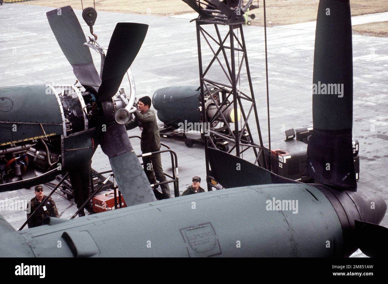 U.S. Air Force technicians service a C-130 Hercules aircraft engine ...