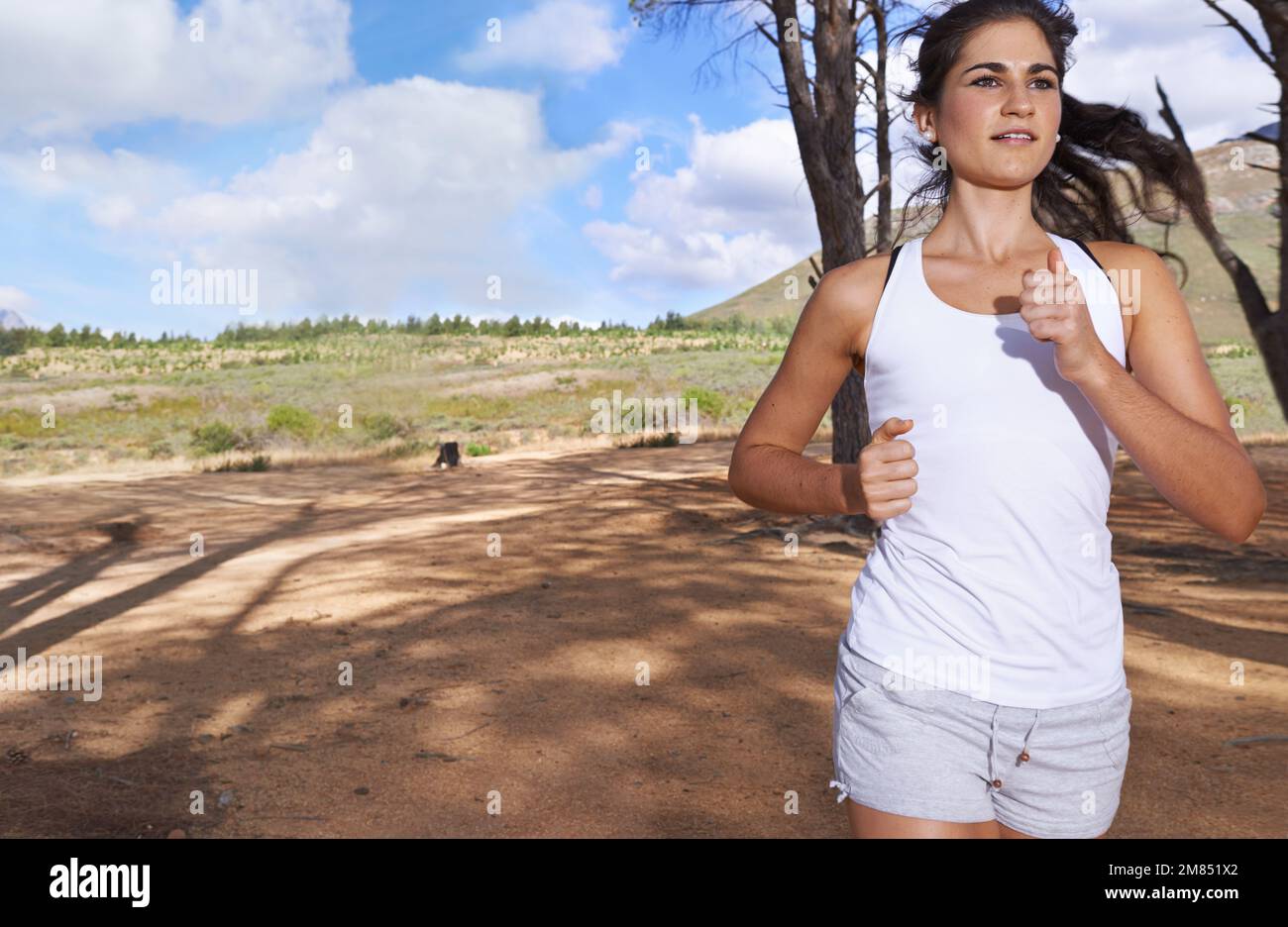 Exploring nature while keeping fit. A young female runner jogging ...
