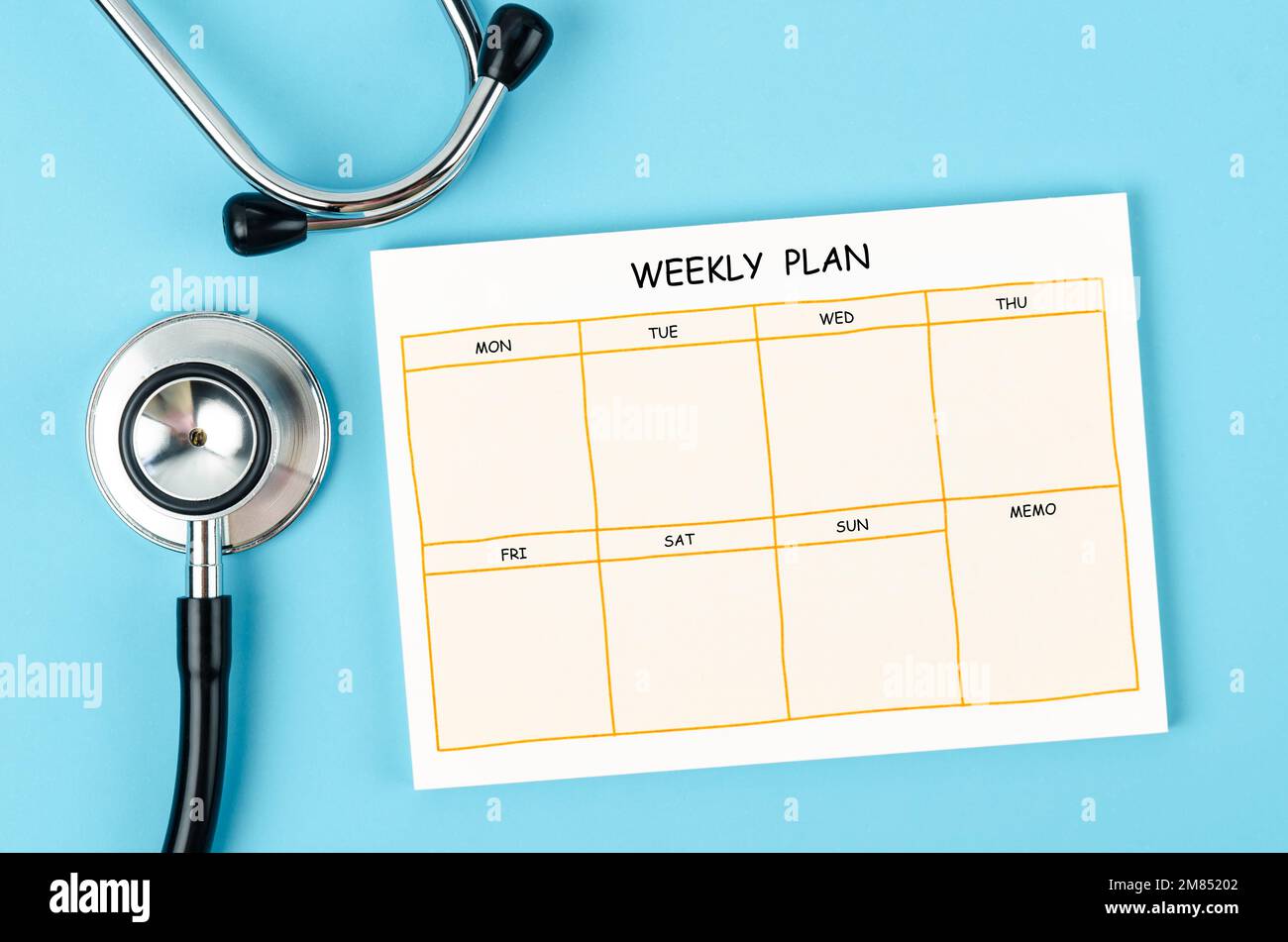 Blank weekly plan notice block and medical stethoscope on blue colour ...