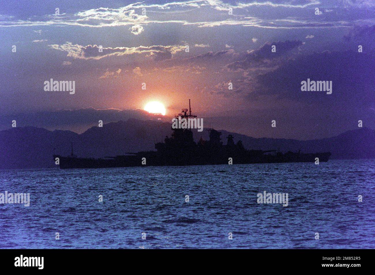 A port side view of the battleship USS IOWA (BB-61) at sunset. Base ...