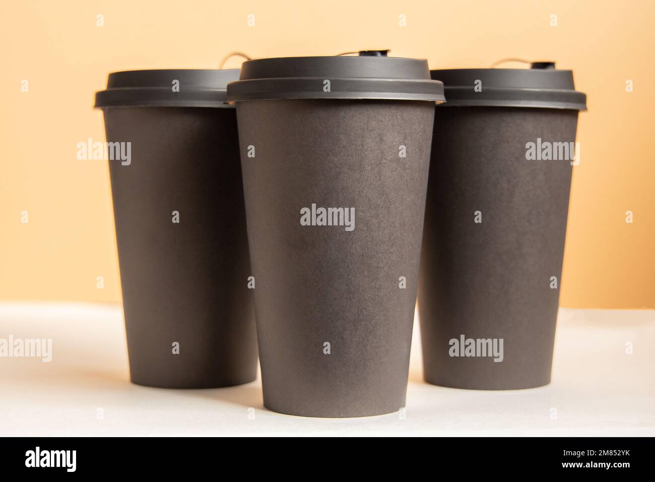 Set of three takeaway black coffee cup on neutral background natural ...