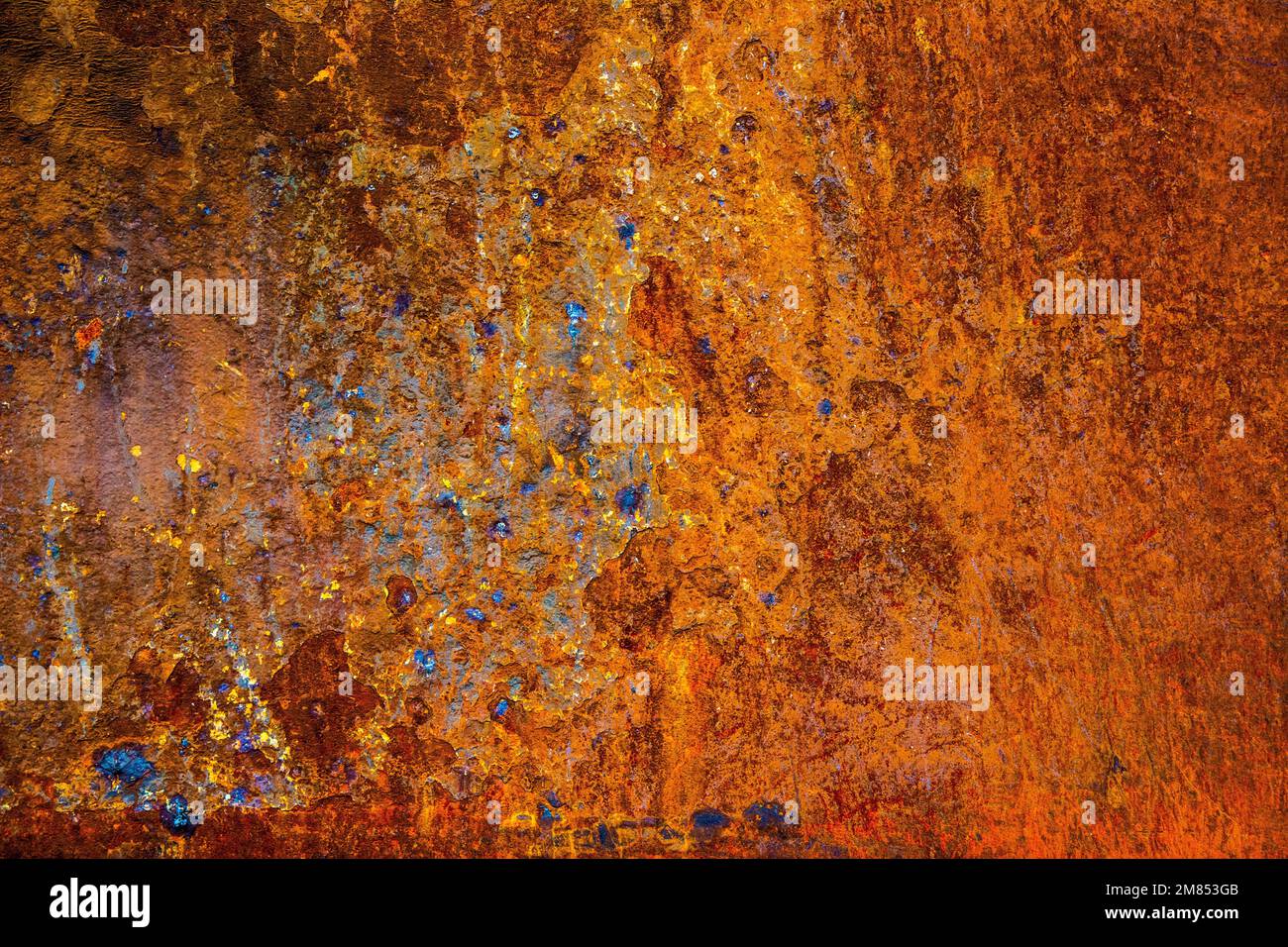 Beautiful rusted iron texture with atractive spots of blue and yellow ...
