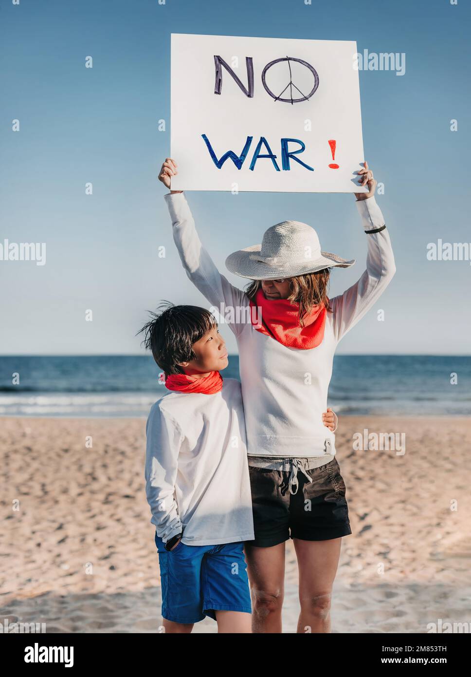 a mother and her asian son look at each other as the mother holds up a ...