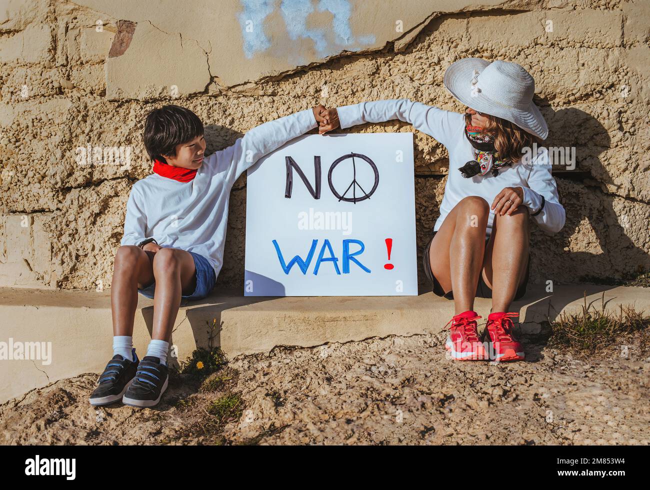 a mother and her asian son are sitting in front of a bunker and in the ...