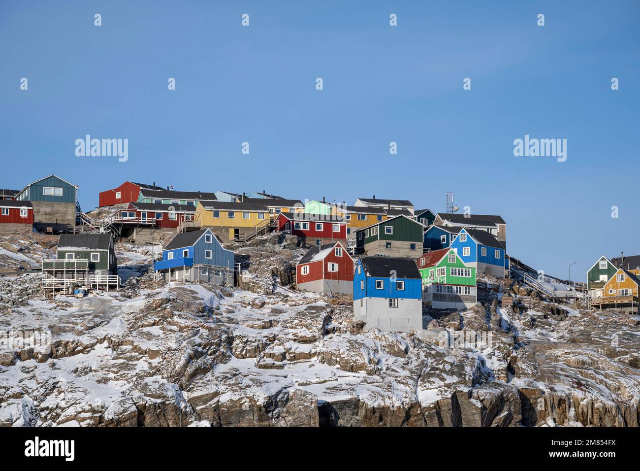 Colourful houses clinging to the side of the mountain at Uummannaq in ...