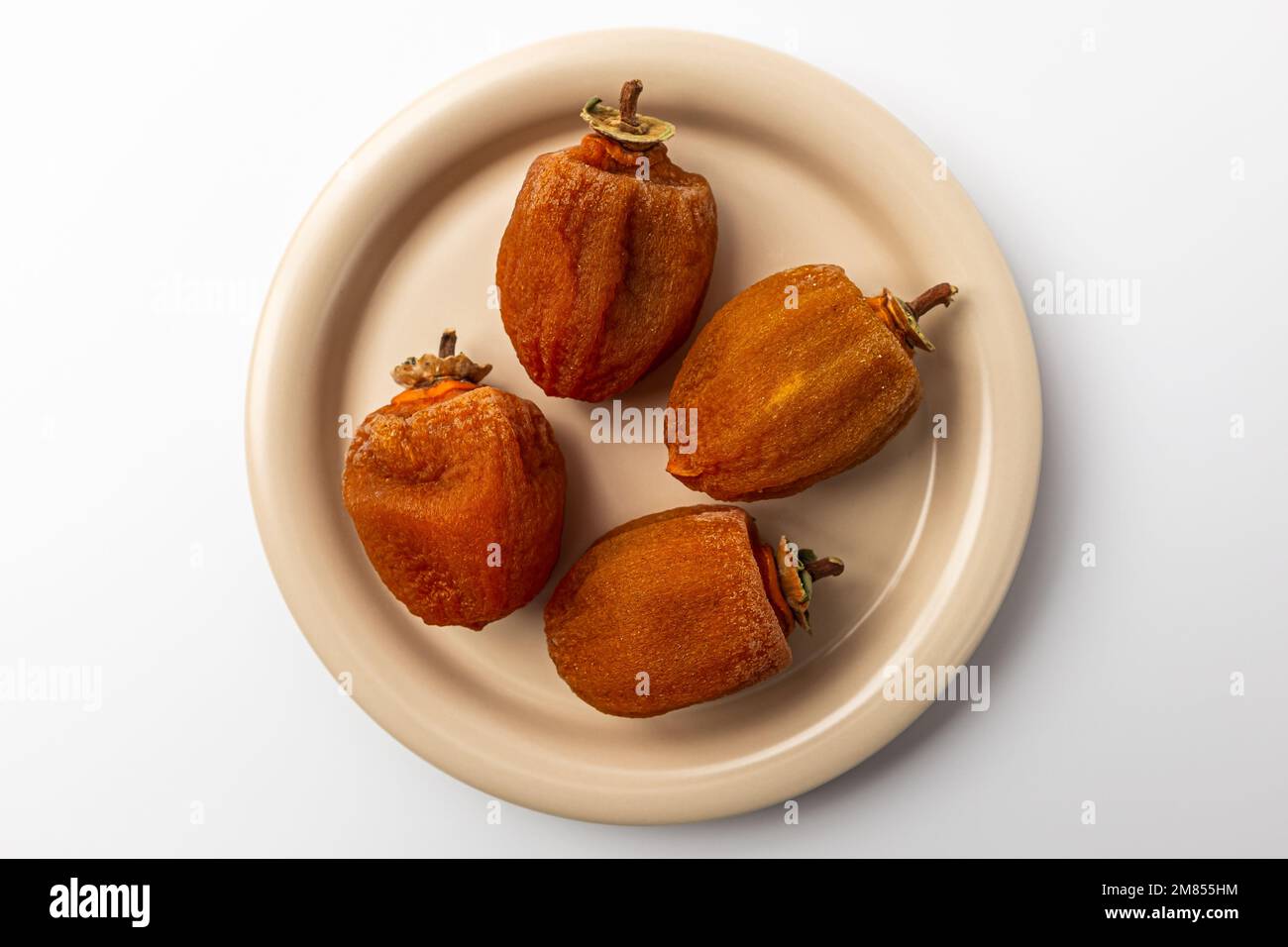 Half dried persimmon on a white background Stock Photo - Alamy
