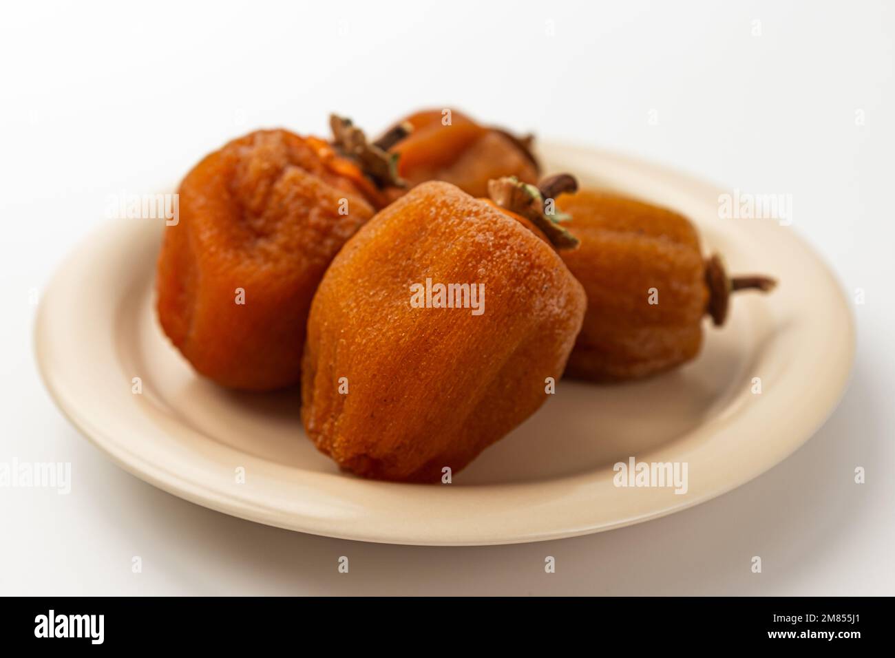 Half dried persimmon on a white background Stock Photo - Alamy