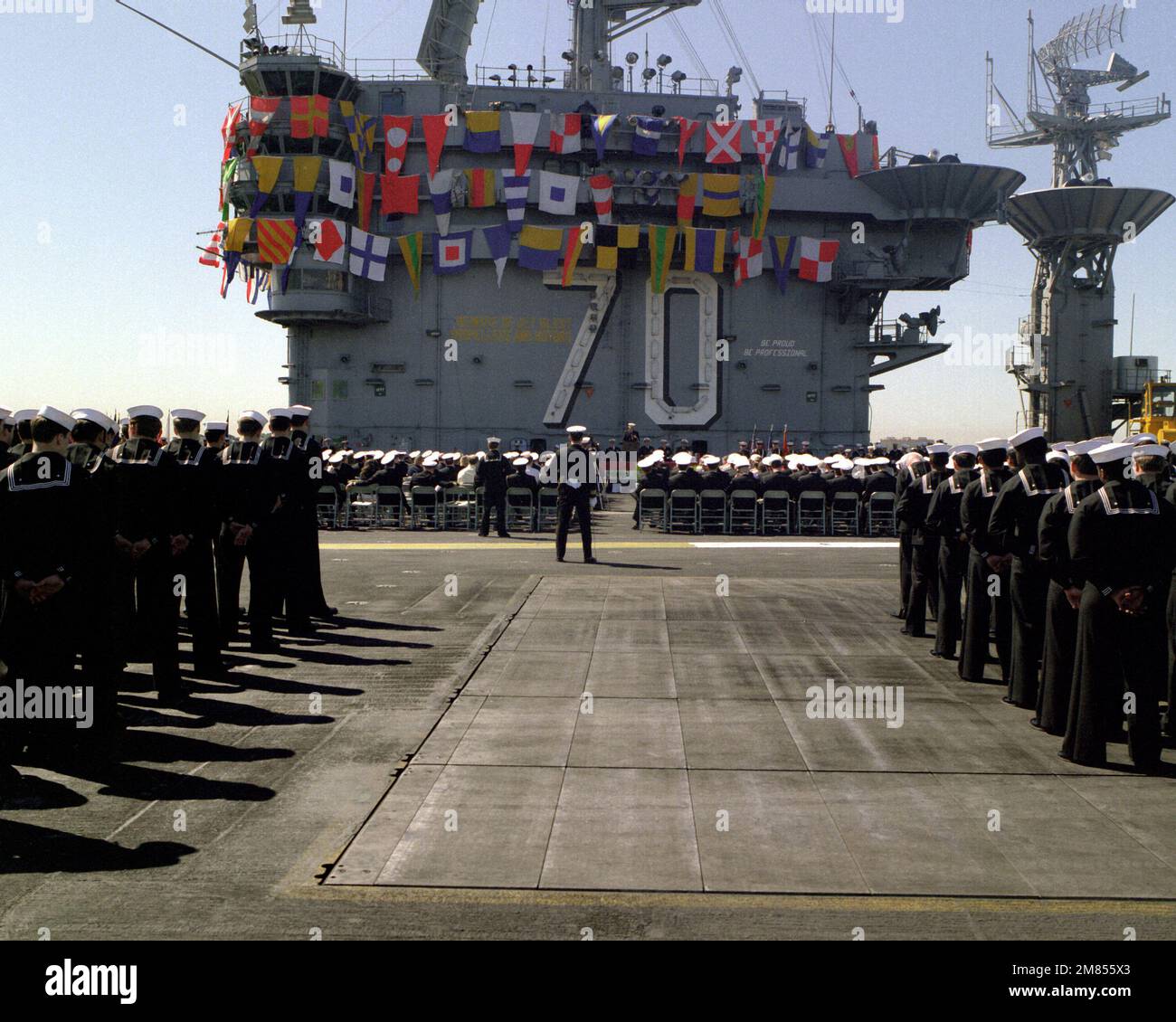 Crewmen stand in formation on the flight deck during the change of ...