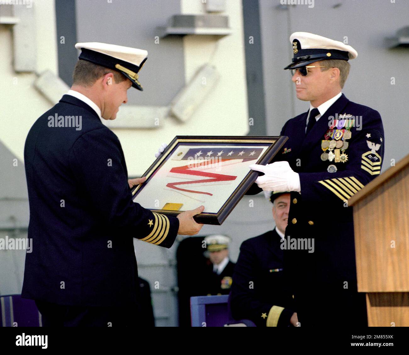 A master chief petty officer presents the commissioning pennant to CAPT ...