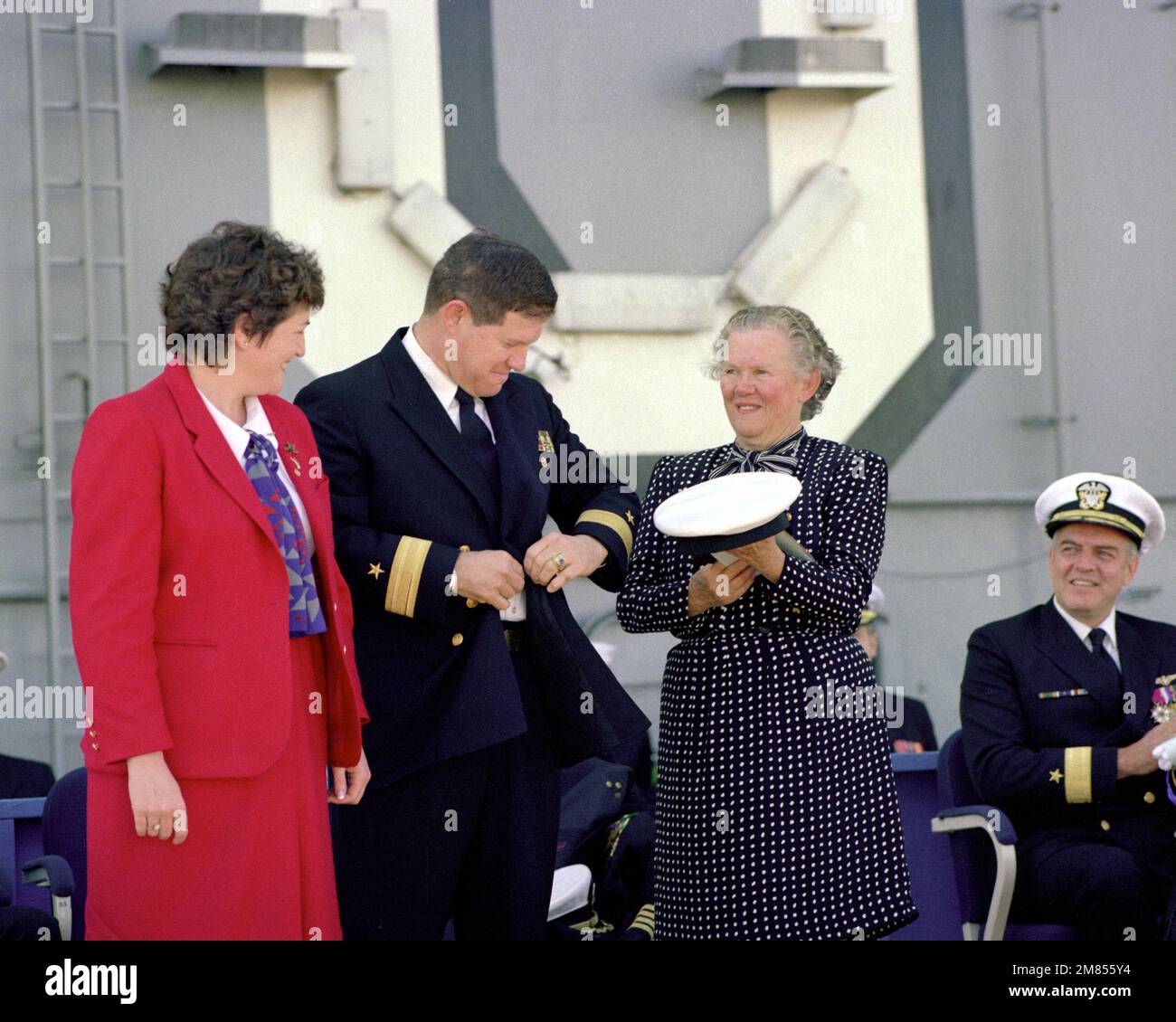 CAPT. Thomas A. Mercer puts on his rear admiral (lower half) jacket ...