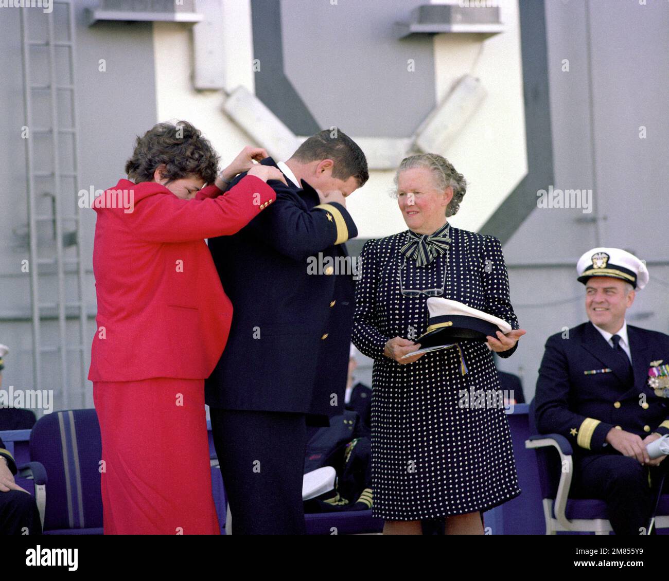 CAPT. Thomas A. Mercer puts on his rear admiral (lower half) jacket ...
