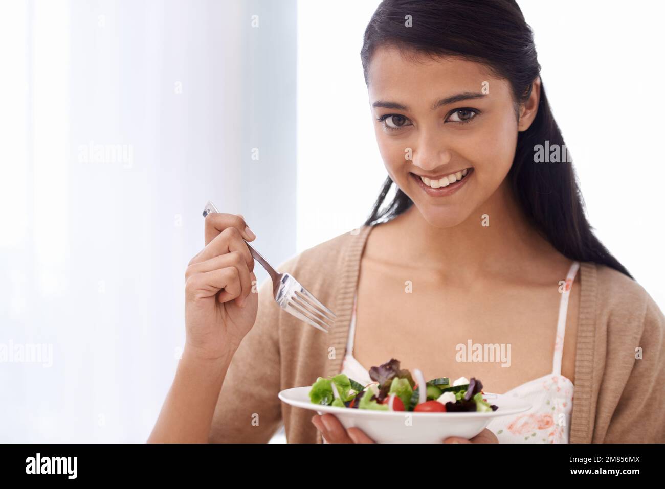 Eating right is important to me. A beautiful young woman enjoying a healthy snack from the ...