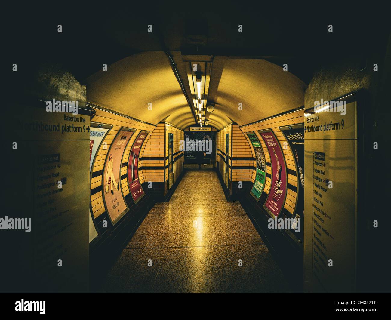 A hallway lit by dim yellow lights in an old station in the London ...