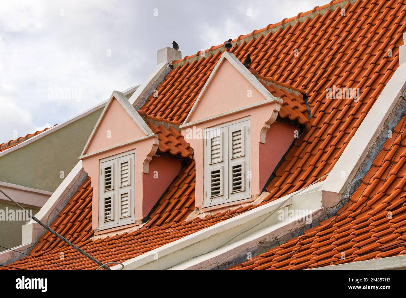 WILLEMSTAD, CURACAO - NOVEMBER 22, 2007: Two pink dormers on a tiled ...