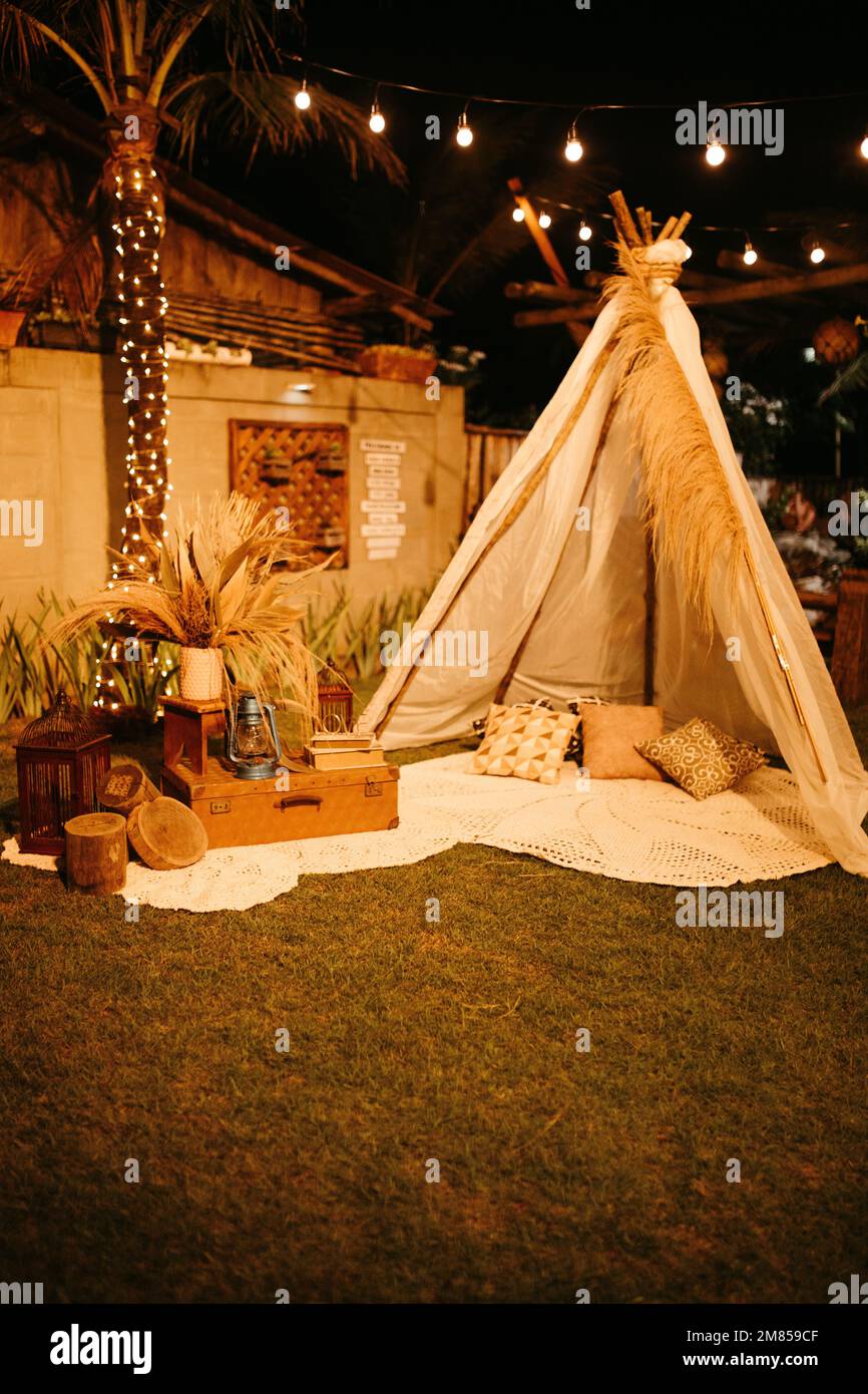 A tipi tent set up in a backyard with wooden decorations Stock Photo ...