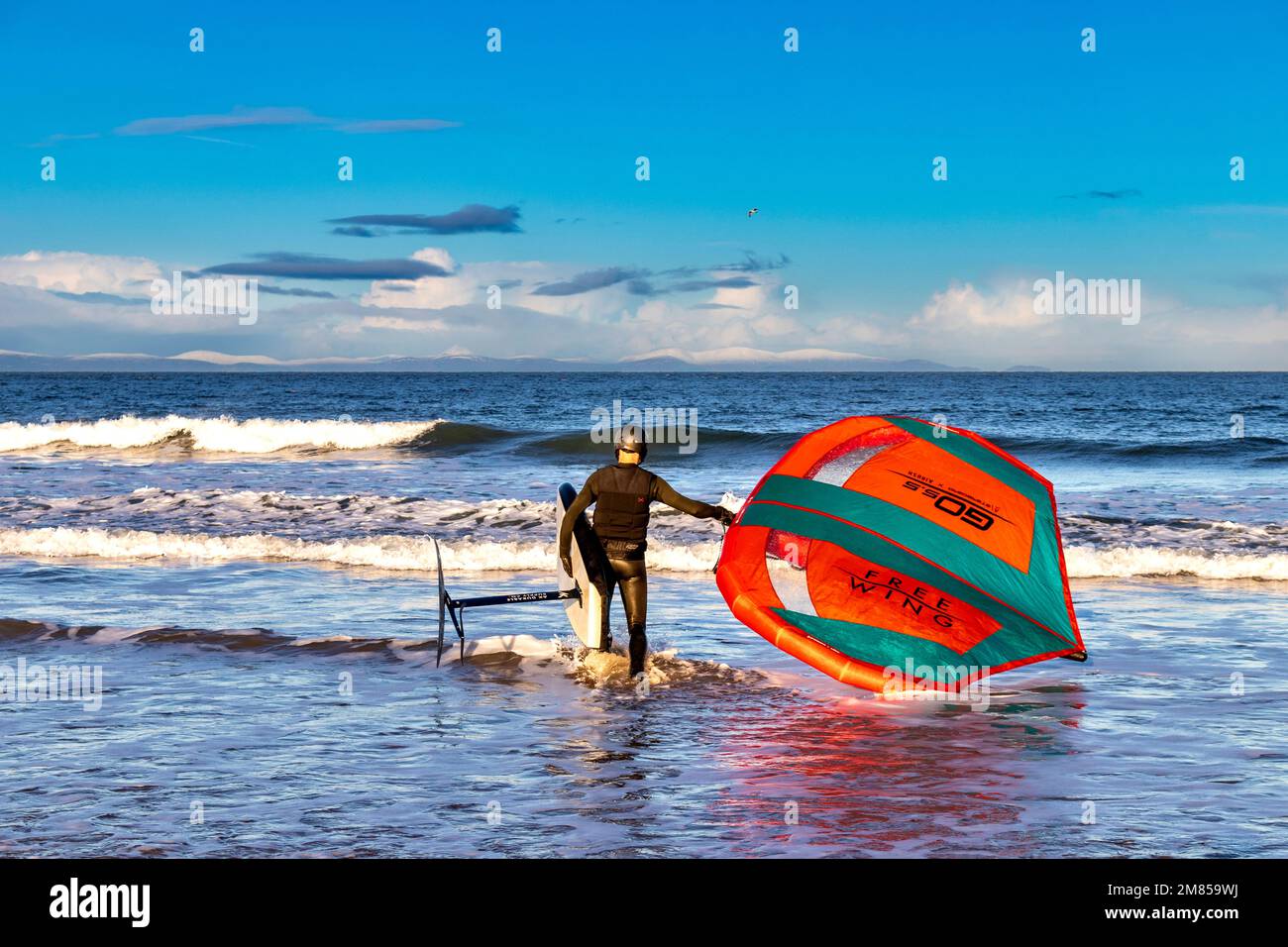 Lossiemouth West Beach windsurfer entering sea with foil and airush ...