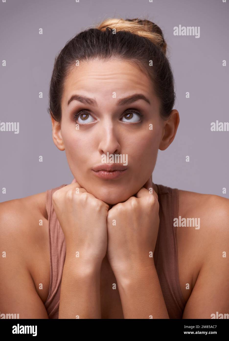 Deep thoughts. An attractive young woman against a purple background ...