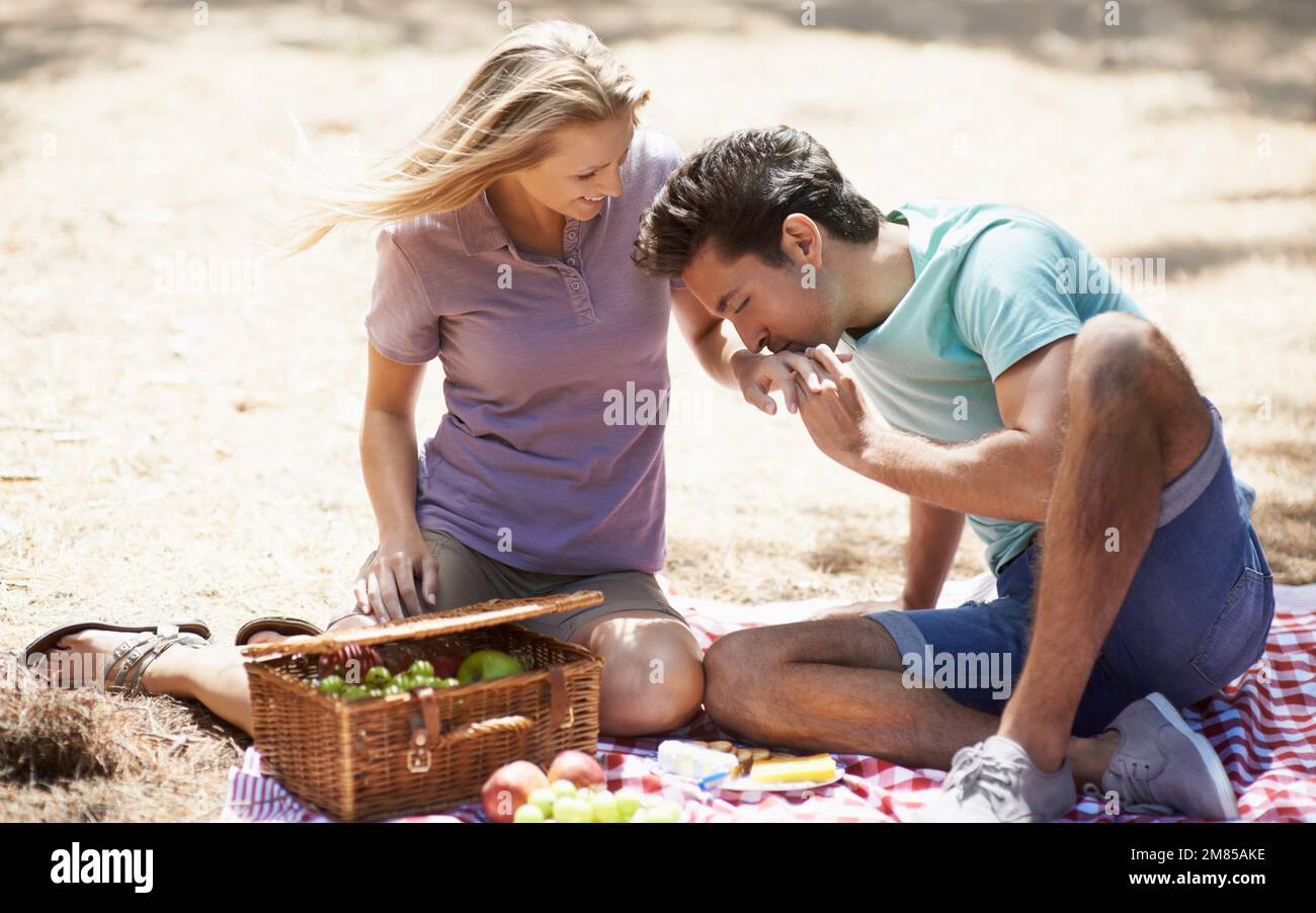 The perfect date. An affectionate young couple enjoying a summer picnic ...