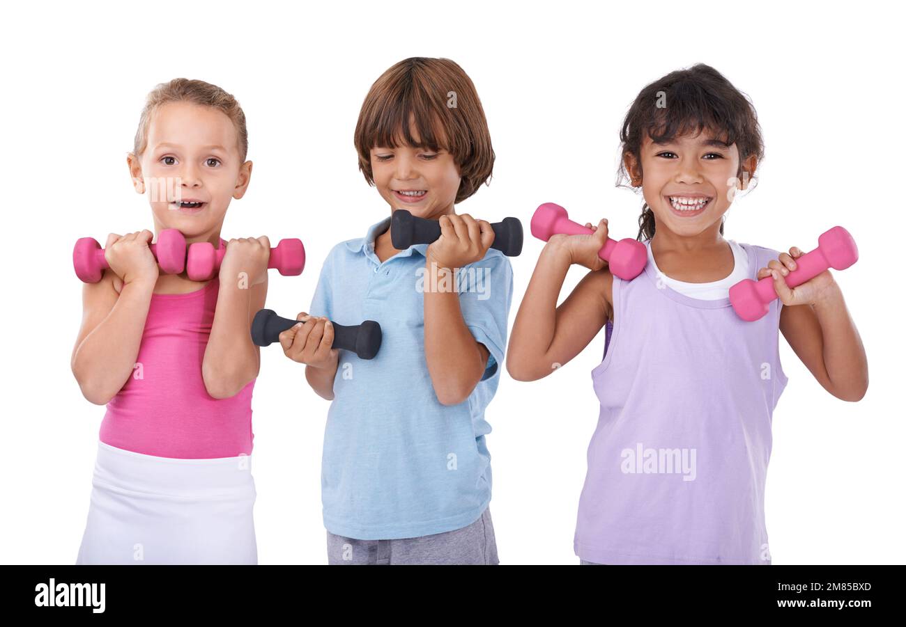 Big and strong. Three young children lifting dumbbells against a white ...