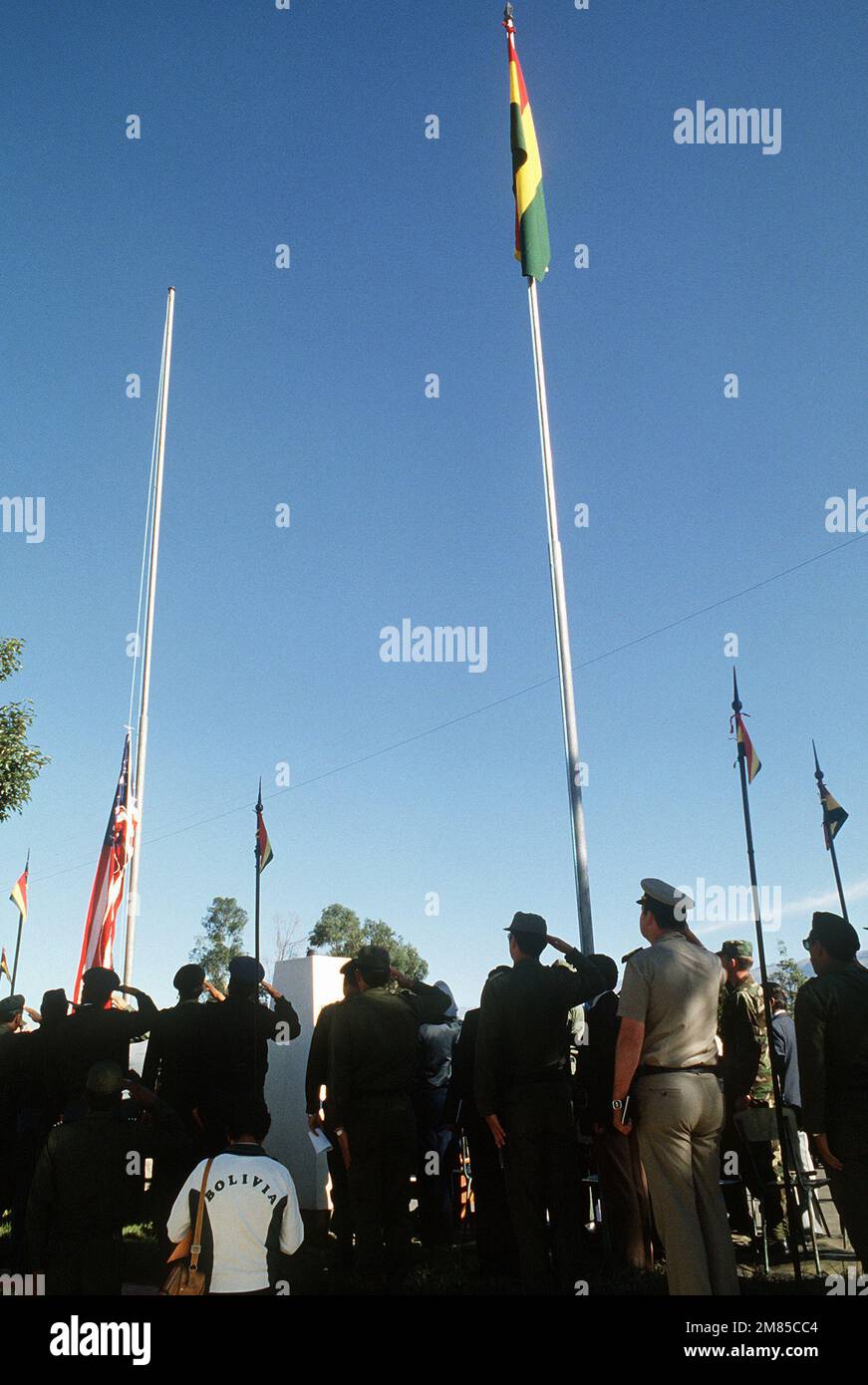 Military personnel raise the Bolivian and U.S. flags in a ceremony ...