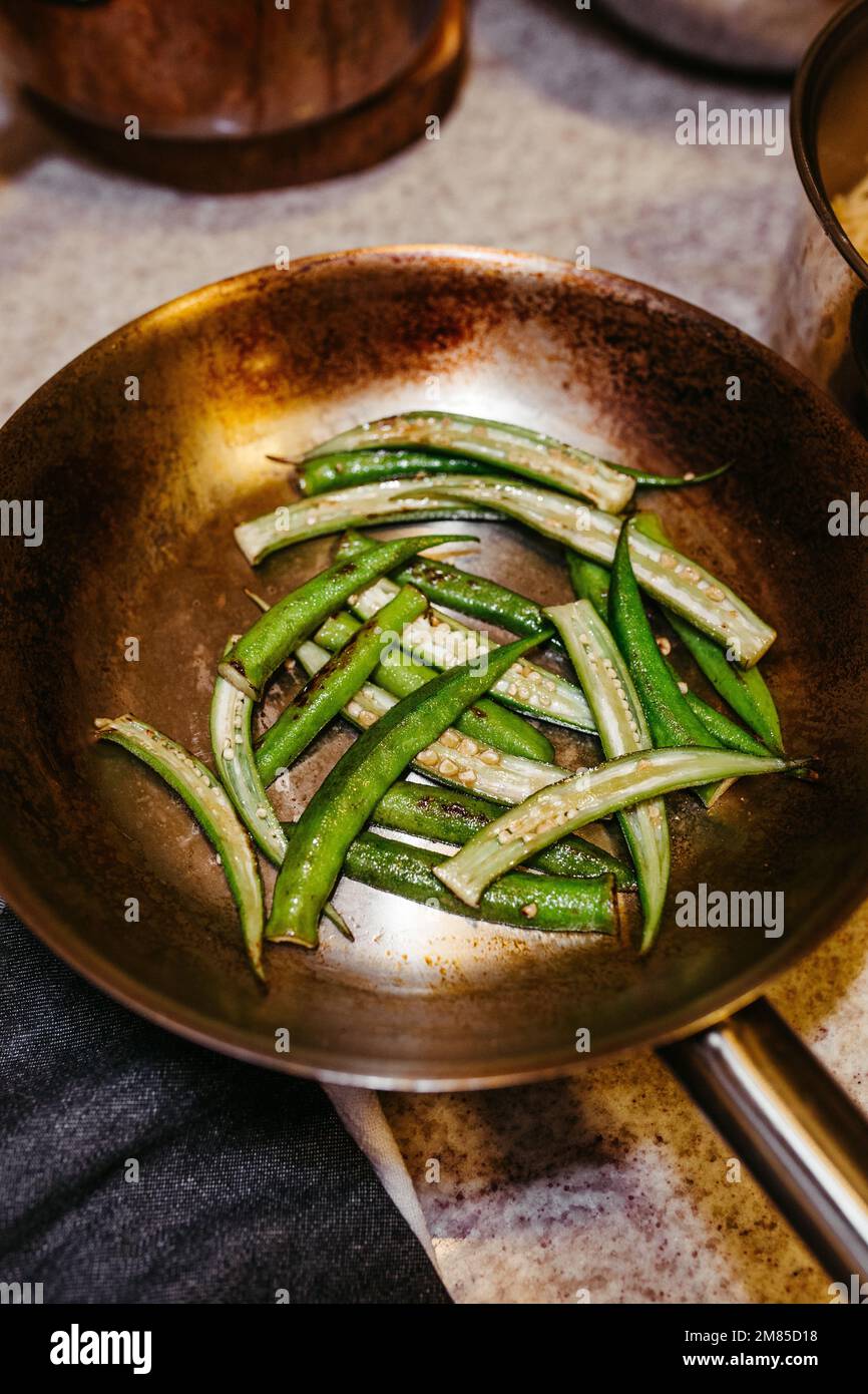 A high-angle shot of the Green Beans being fried on the pan on the ...